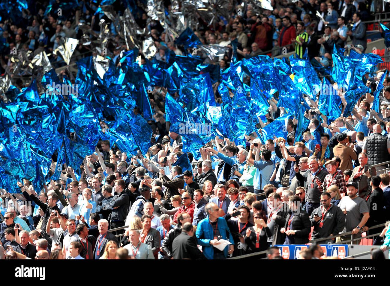 Manchester City fans wave flags in the stands Stock Photo - Alamy