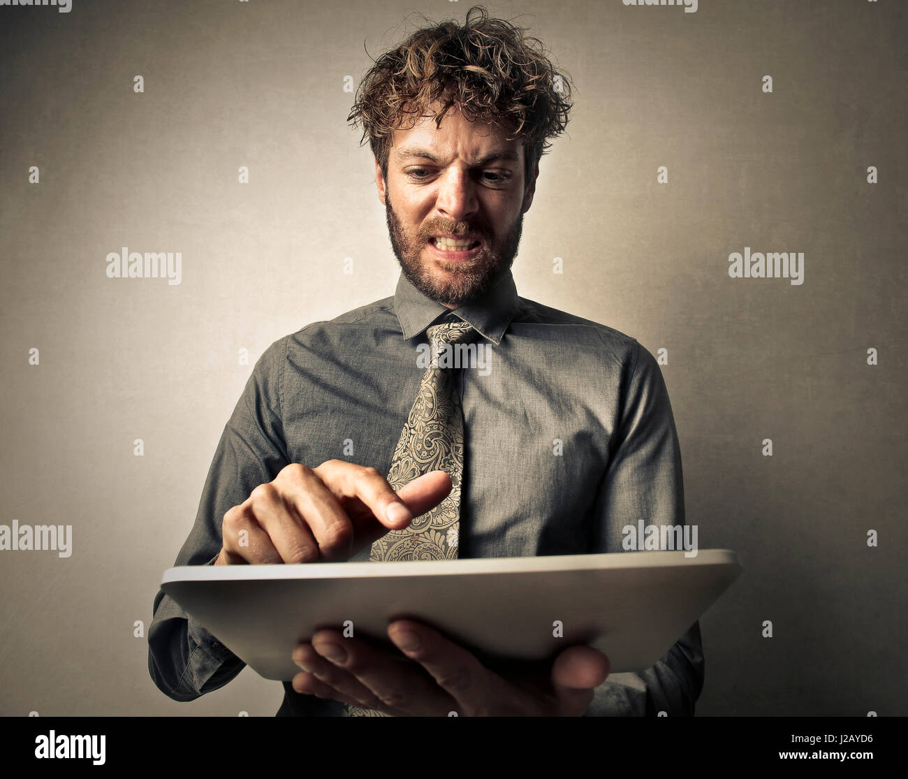 angry businessman with tablet Stock Photo - Alamy