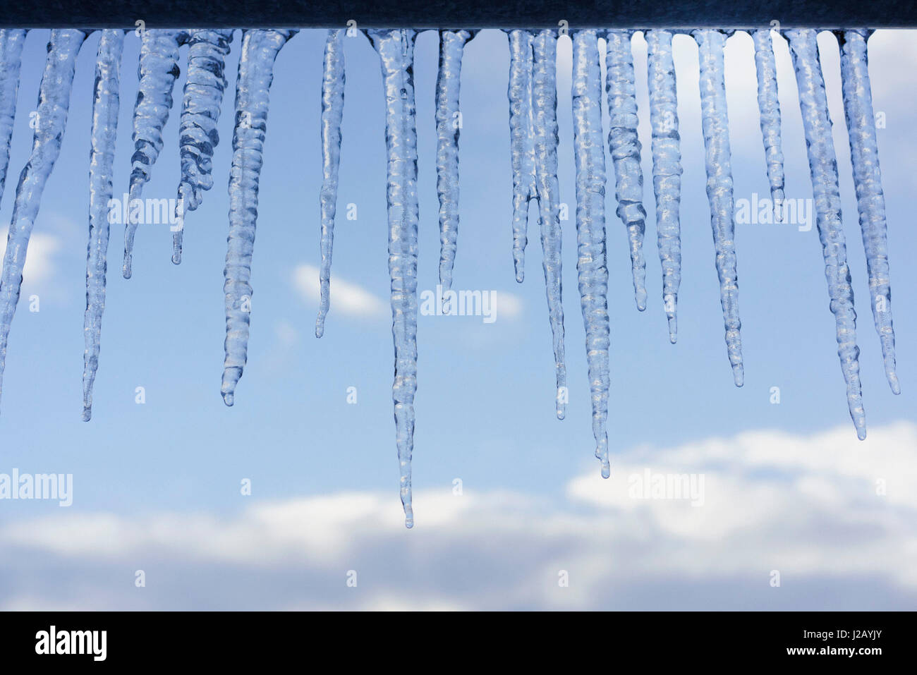 Close-up of icicles on roof edge Stock Photo - Alamy