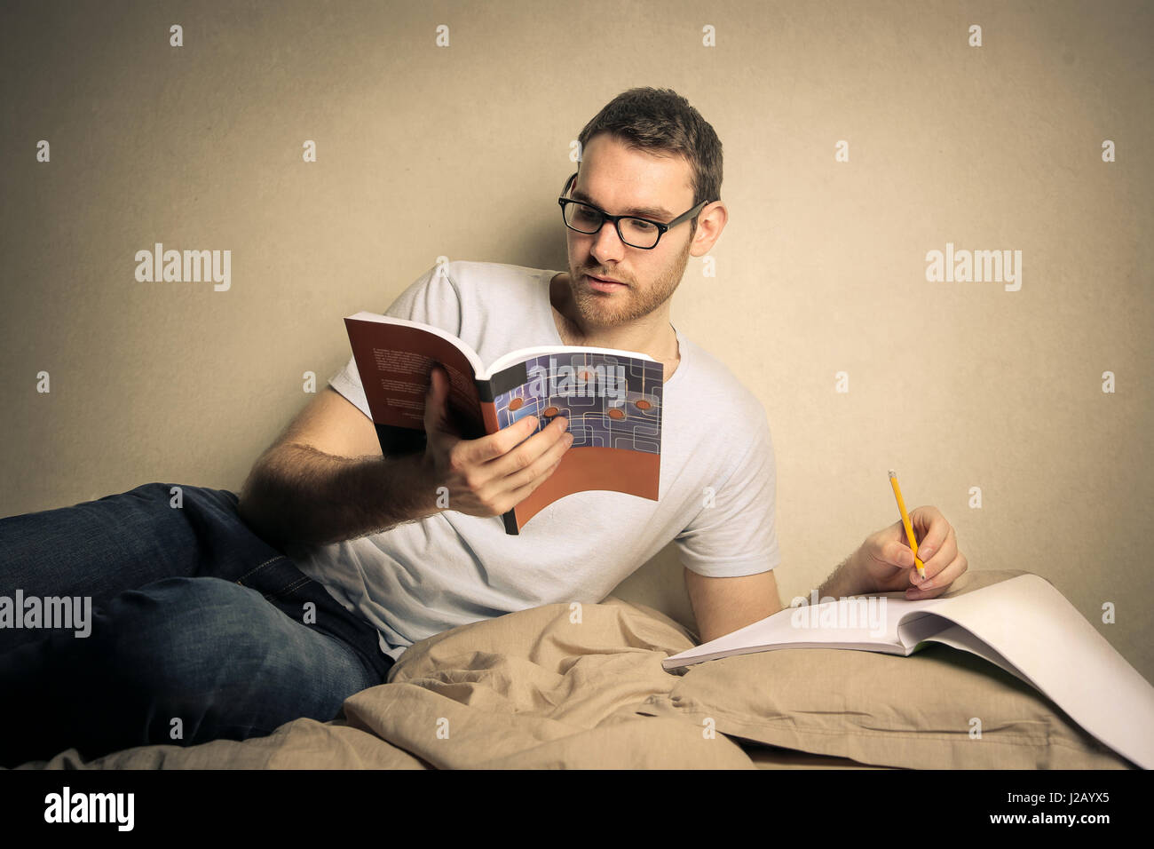 Man studying from books and taking notes Stock Photo - Alamy
