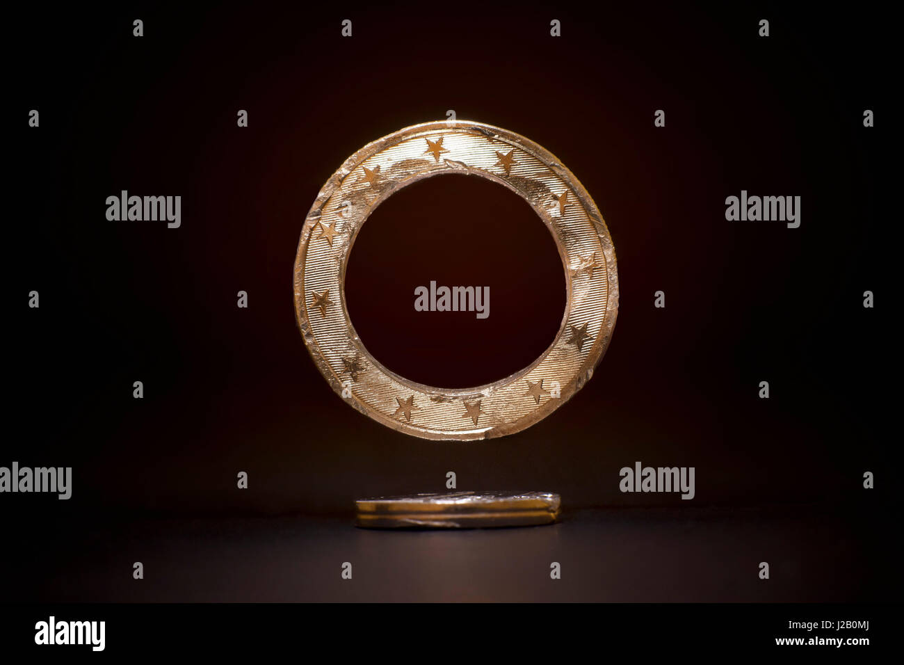 Damaged one Euro coin against black background Stock Photo - Alamy
