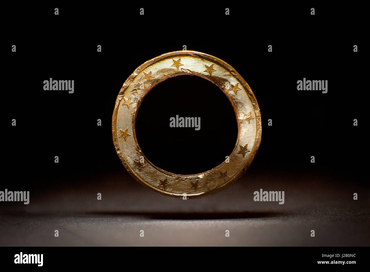 Damaged metal of Euro coin levitating against black background Stock ...
