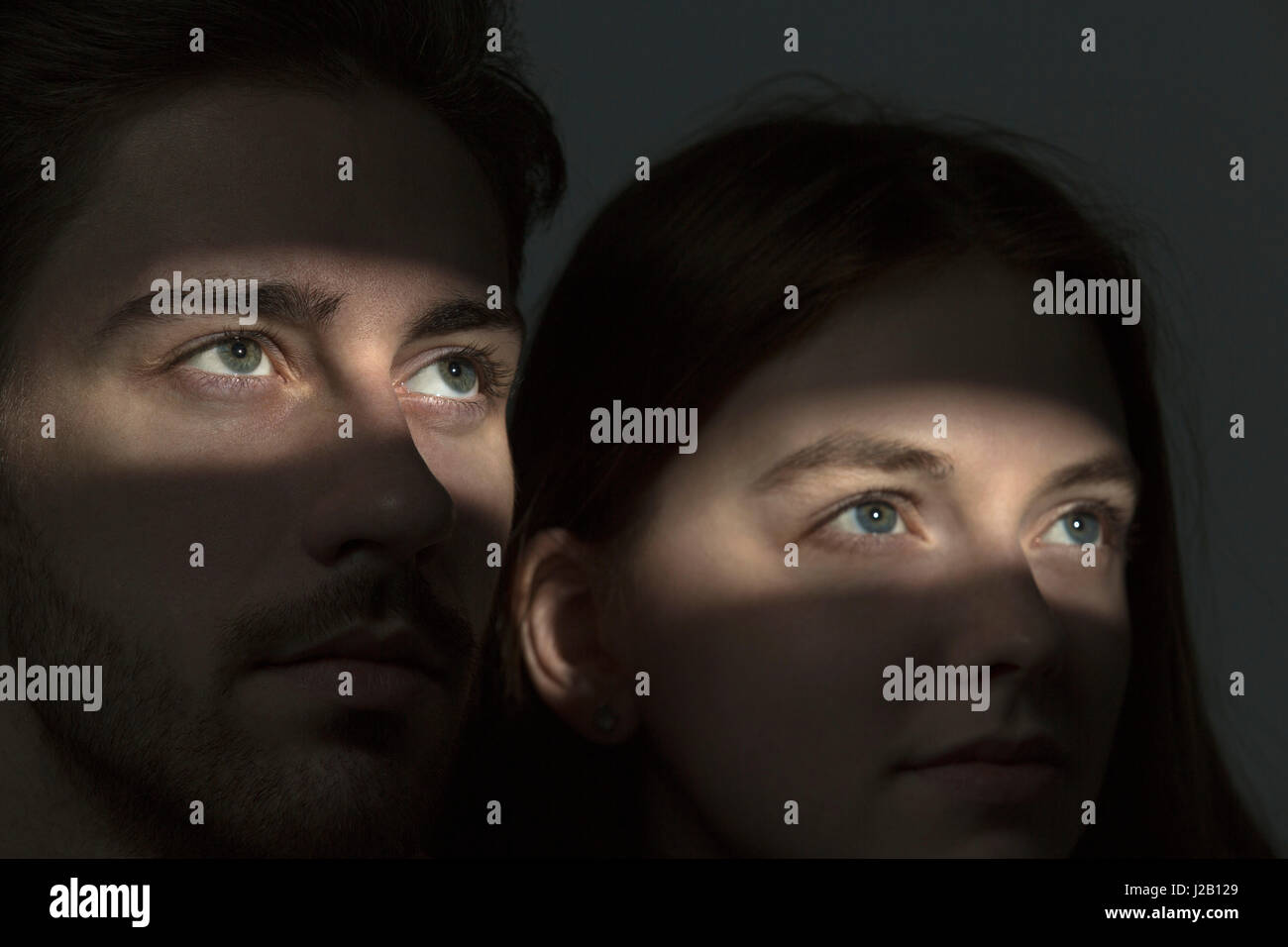 Light falling on couple's eyes in dark Stock Photo - Alamy