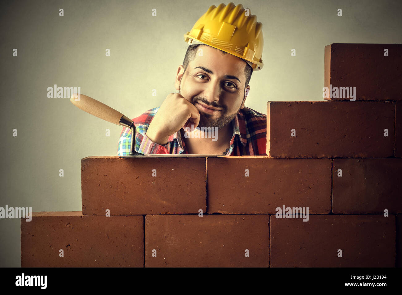 Construction worker building wall Stock Photo - Alamy