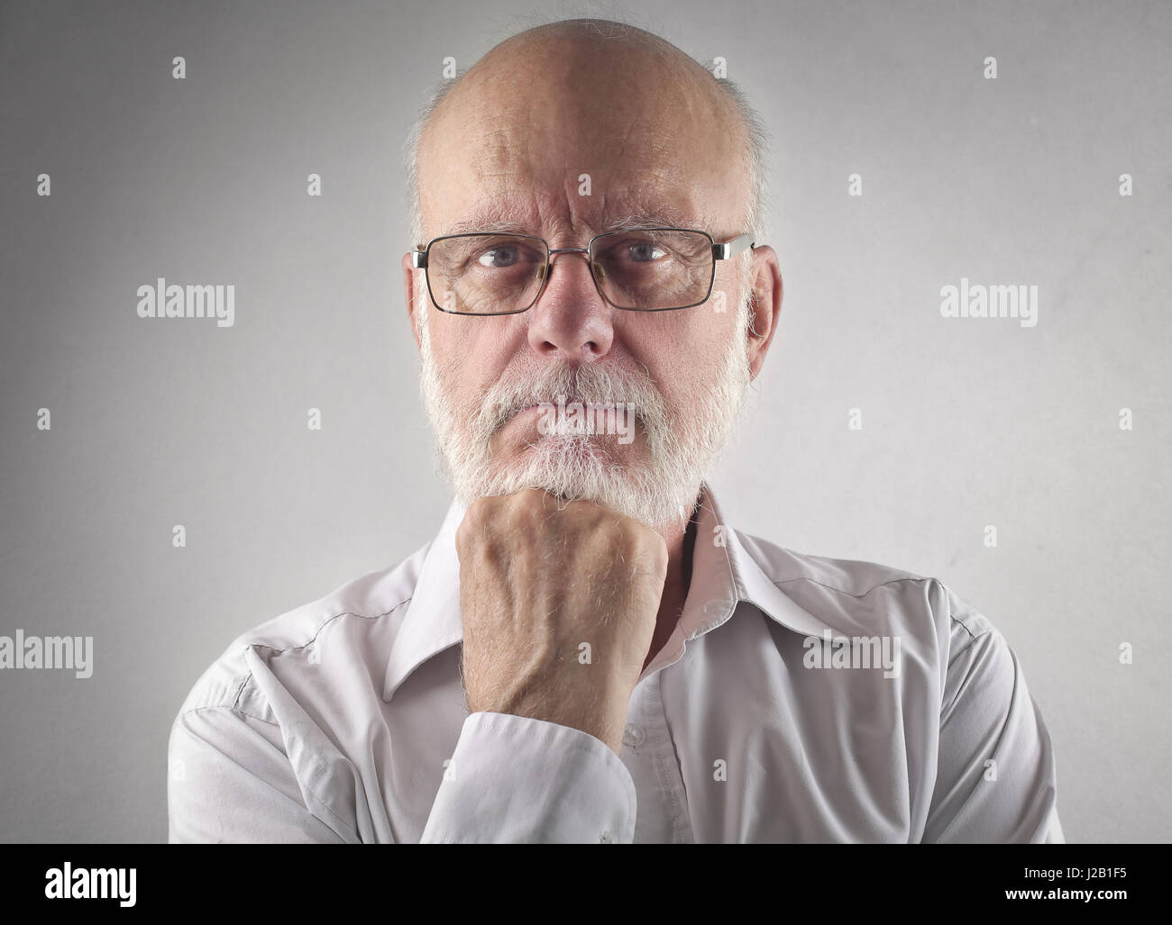 Old man with glasses thinking Stock Photo - Alamy