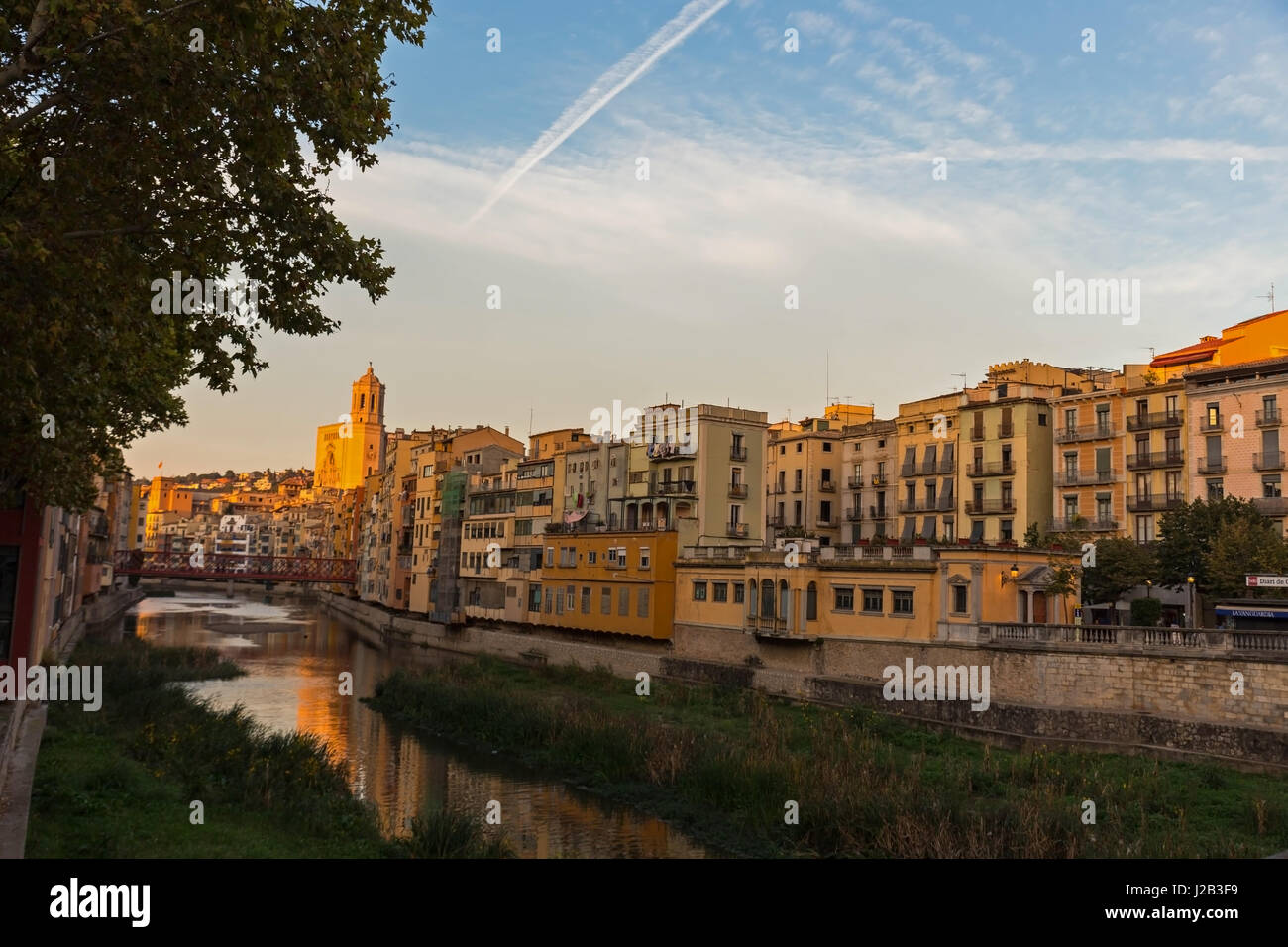 Onyar river crossing the downtown of Girona with bell tower of Basilica ...