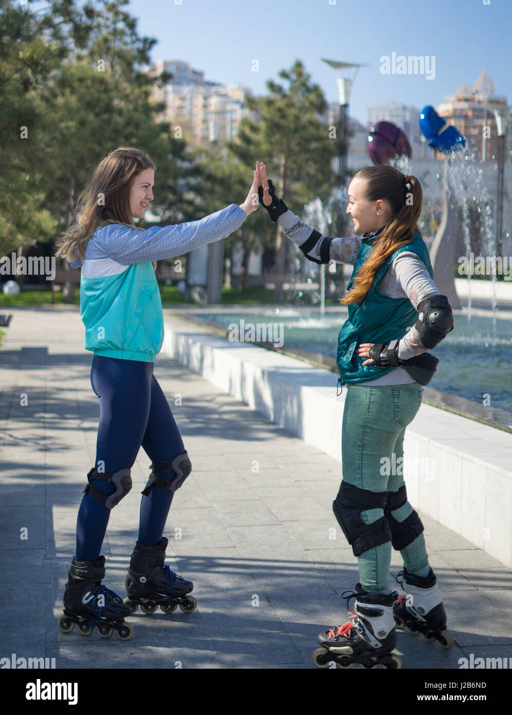 Two girls rollers meet each other in the park Stock Photo - Alamy