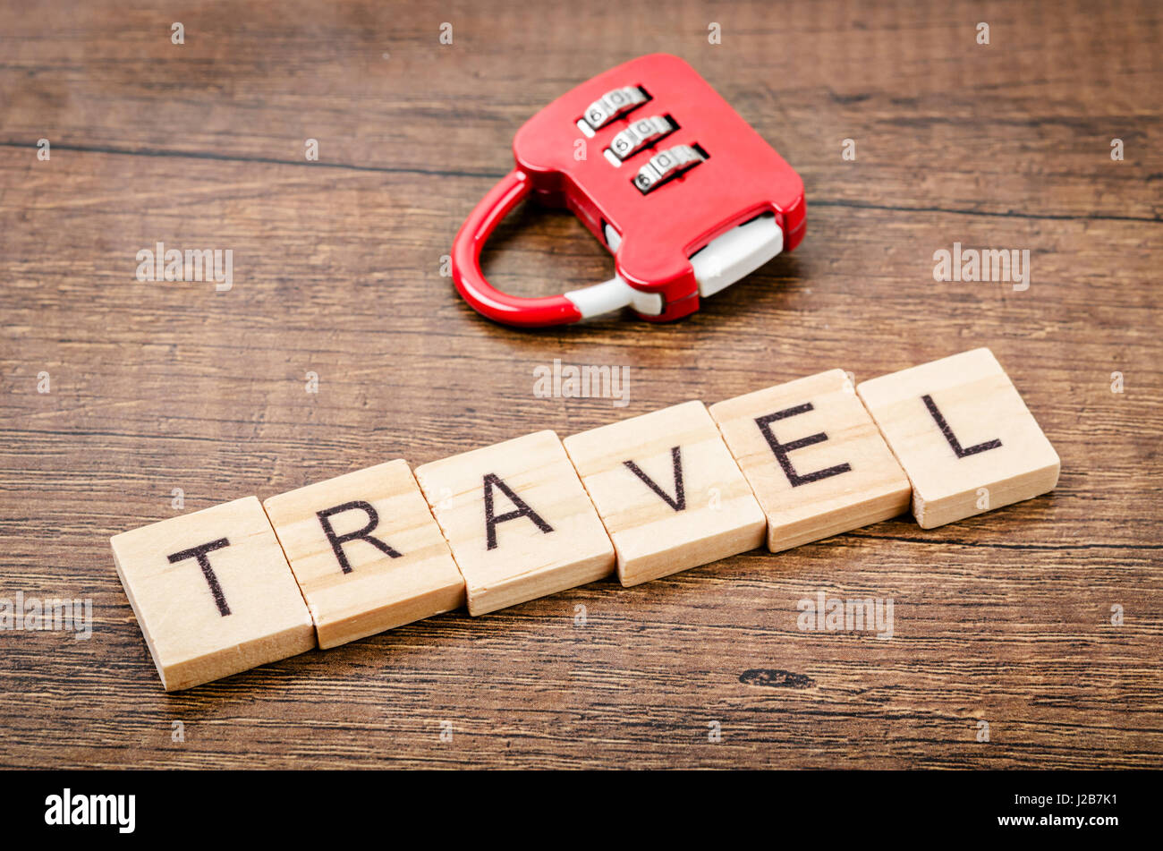 Travel word write on wooden cube with red combination lock on wooden ...
