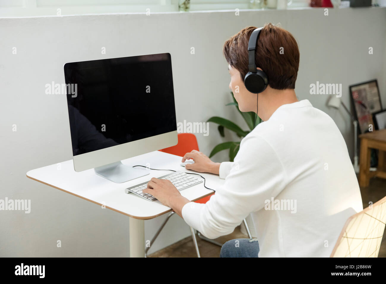 Man with headphones using notebook computer Stock Photo - Alamy