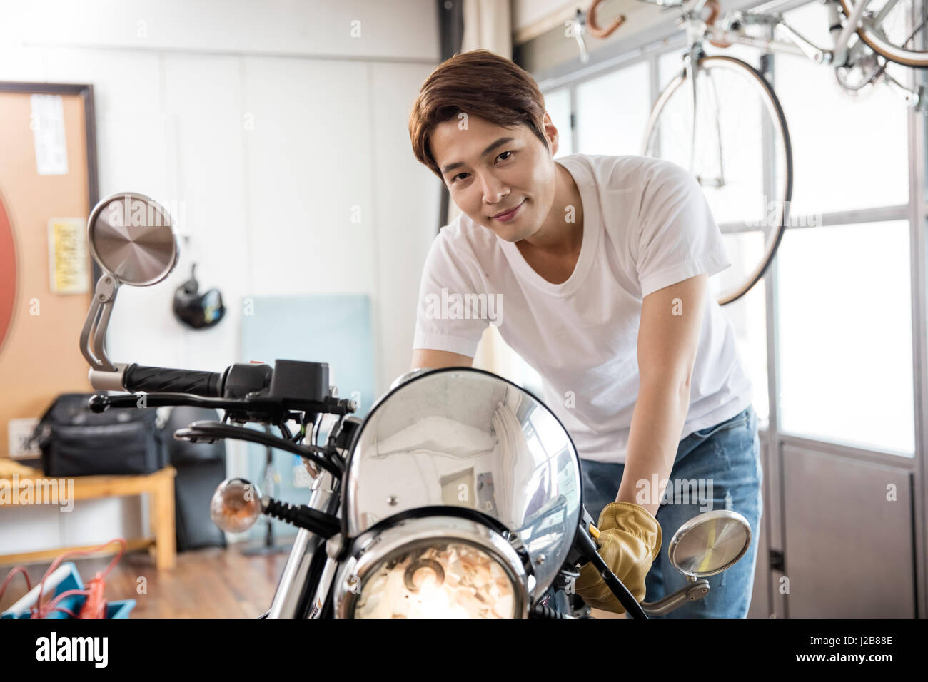 Man posing with motorcycle at workplace Stock Photo - Alamy