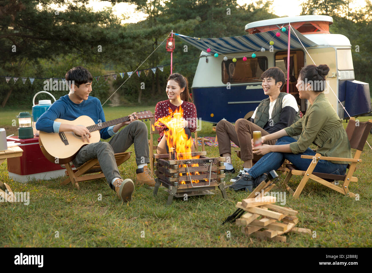 Young smiling people enjoying camping Stock Photo - Alamy