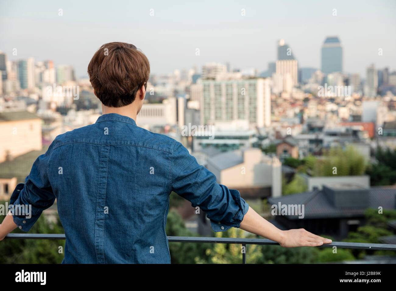Back of man watching view of city Stock Photo - Alamy