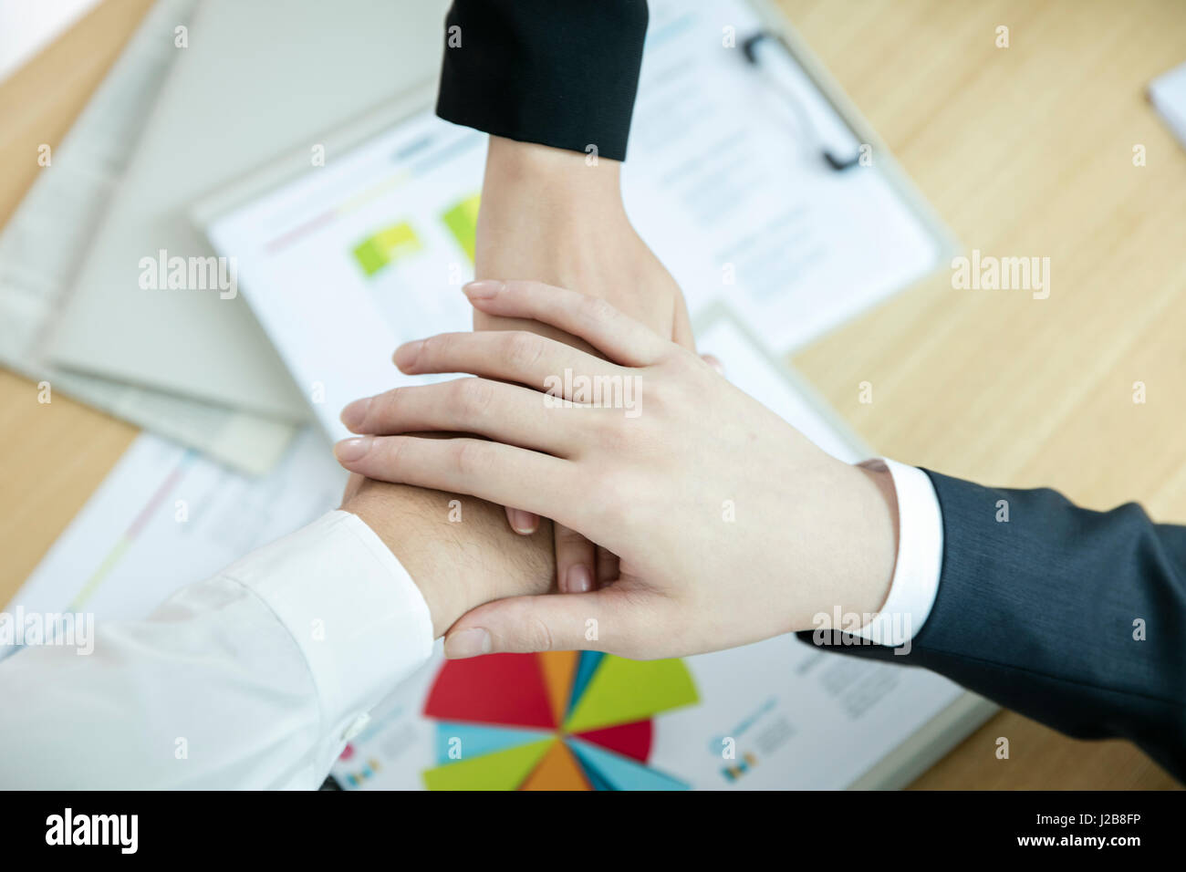 Business people folding hands together Stock Photo - Alamy