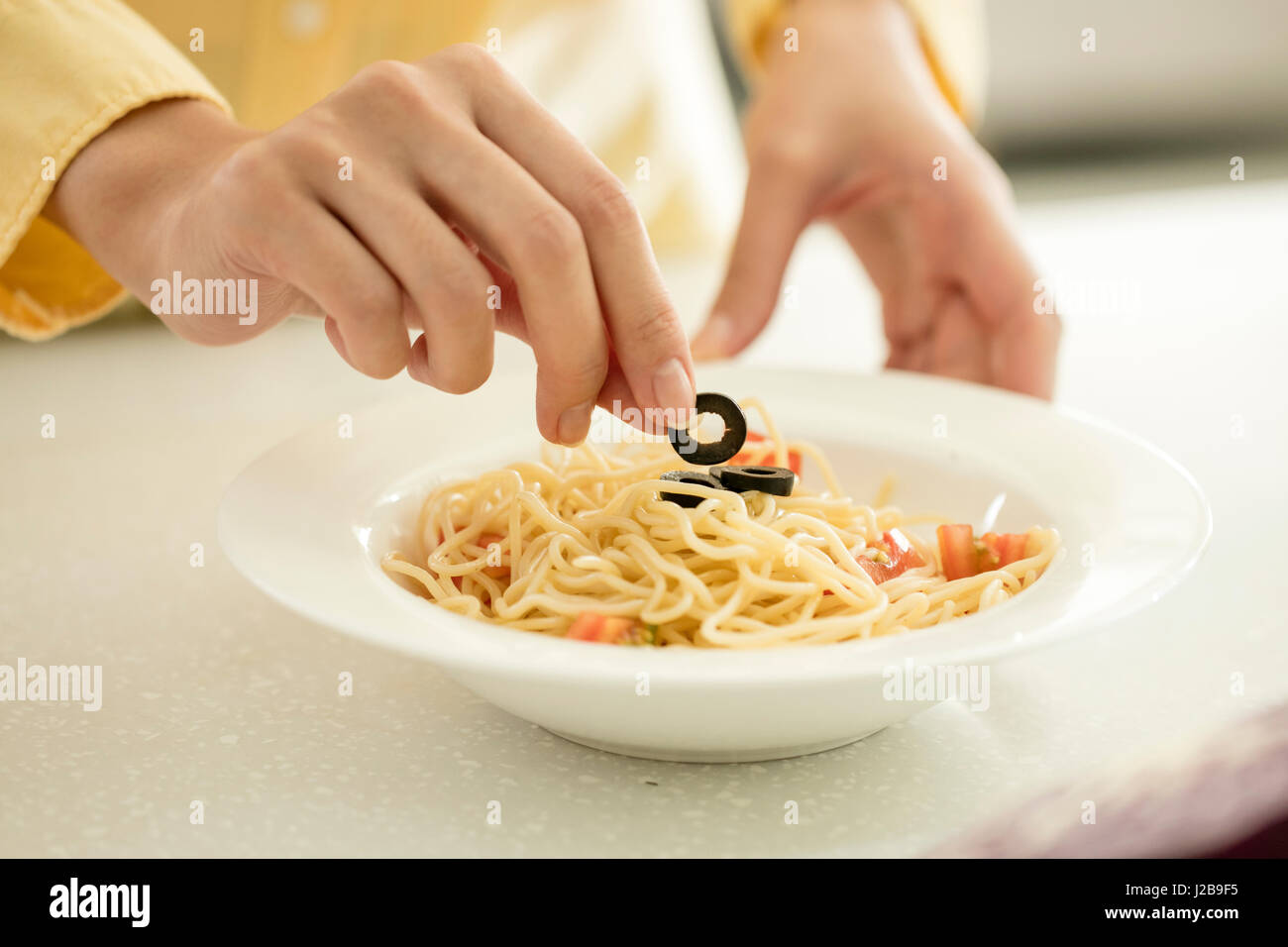 Woman putting topping on spaghetti Stock Photo - Alamy