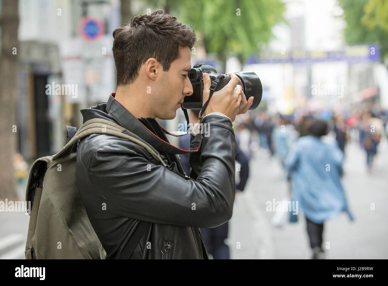 Side view of young male tourist taking photos Stock Photo - Alamy