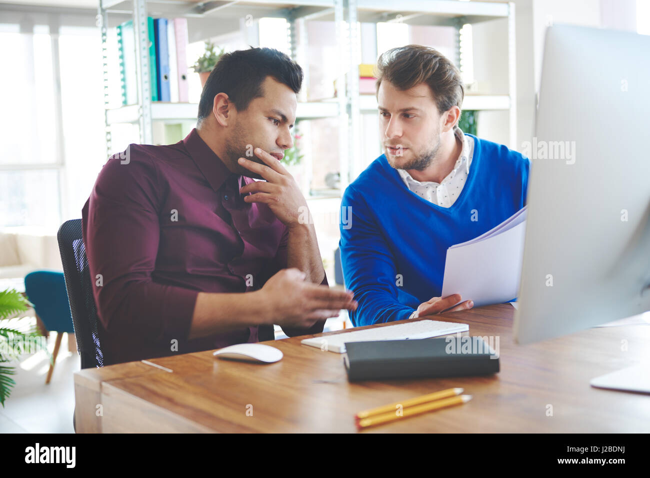 Man looking at magazine together Stock Photo - Alamy