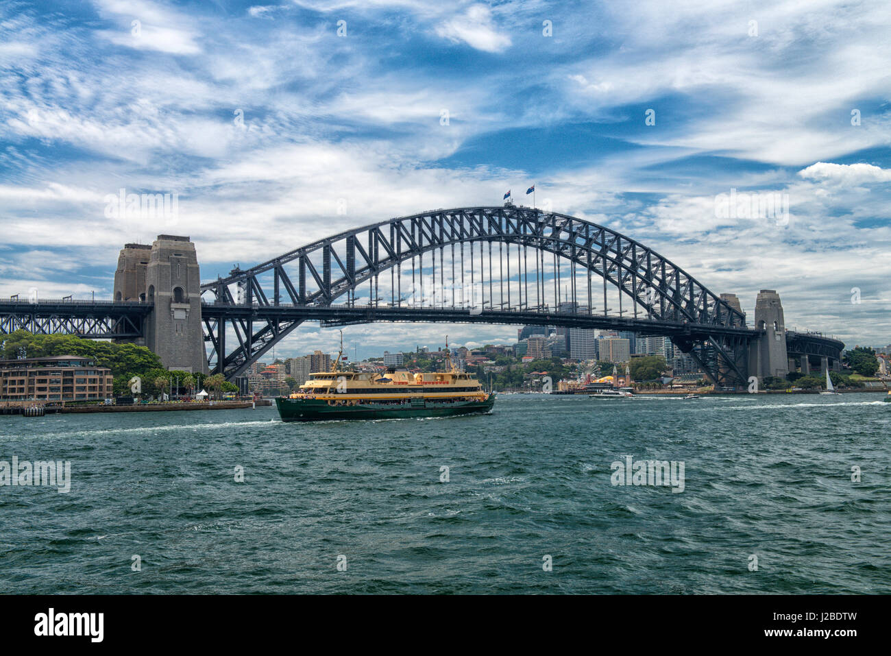 The Manly ferry crosses in front of the iconic Sydney Harbour Bridge as ...