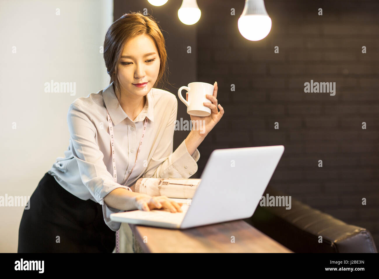 Female fashion designer using a laptop Stock Photo - Alamy