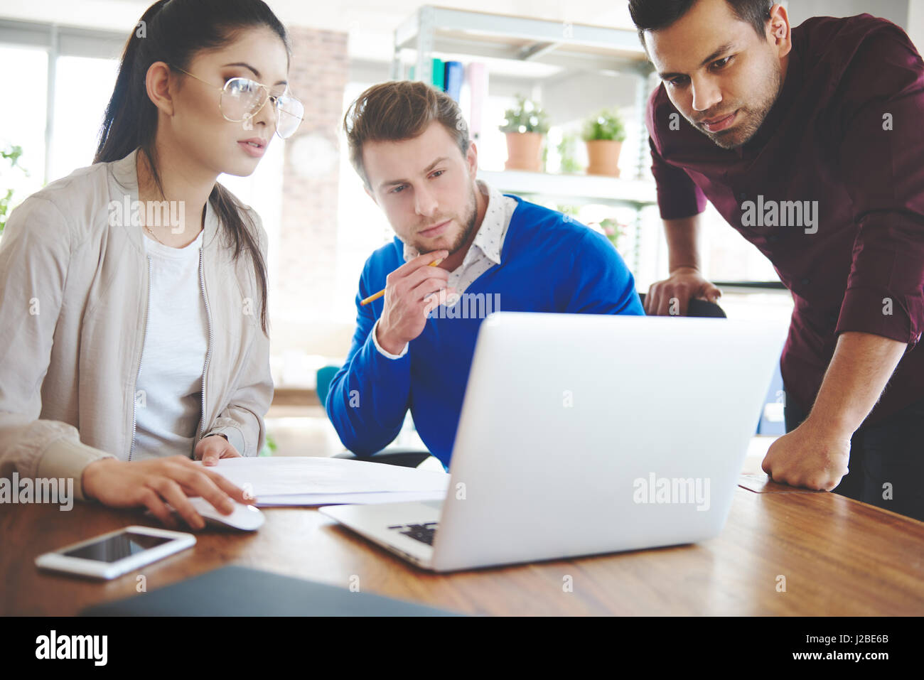 Three young business people over work Stock Photo - Alamy