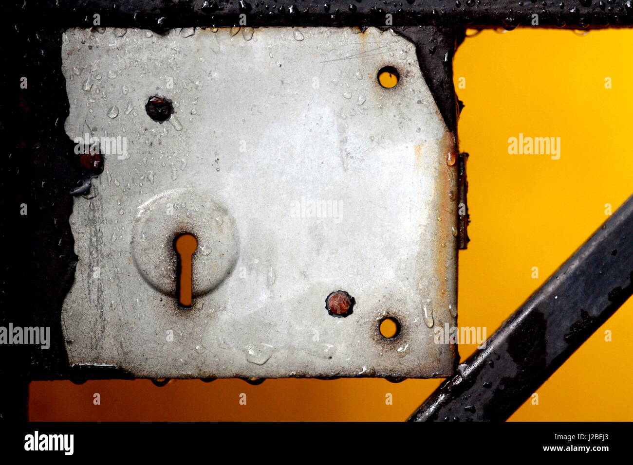 Close up of a traditional black, yellow and grey lock with a keyhole on ...