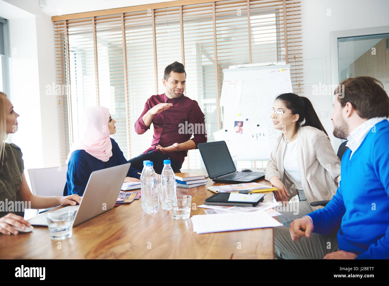 Business people using laptops over meeting Stock Photo - Alamy