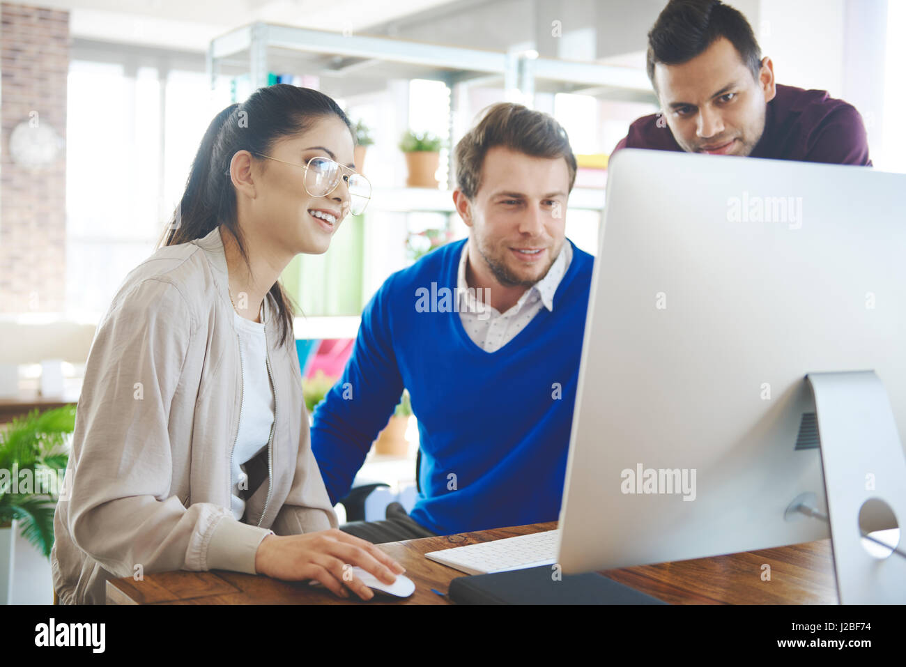 Young coworkers working on computer Stock Photo - Alamy