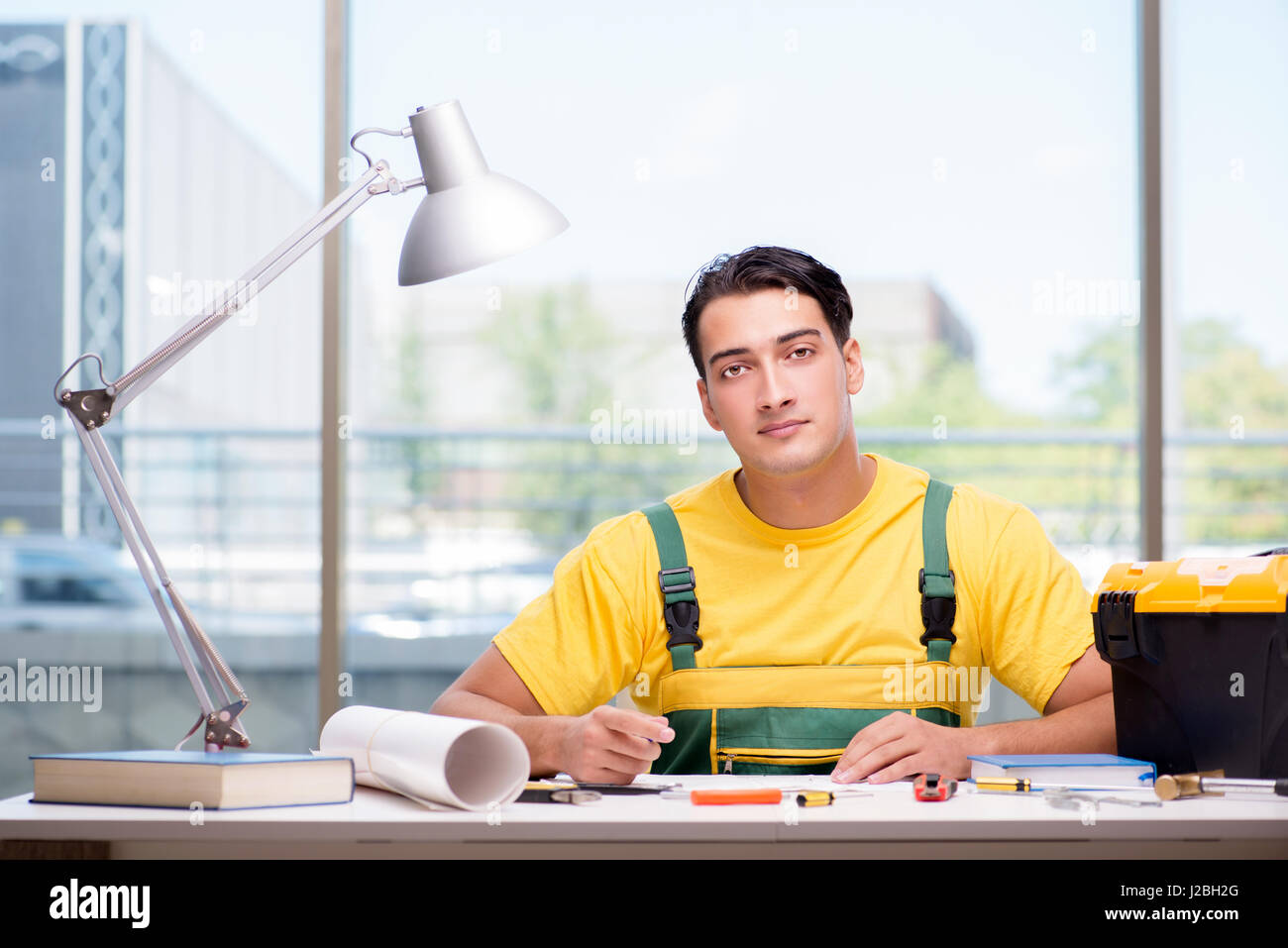 Construction worker sitting at the desk Stock Photo - Alamy