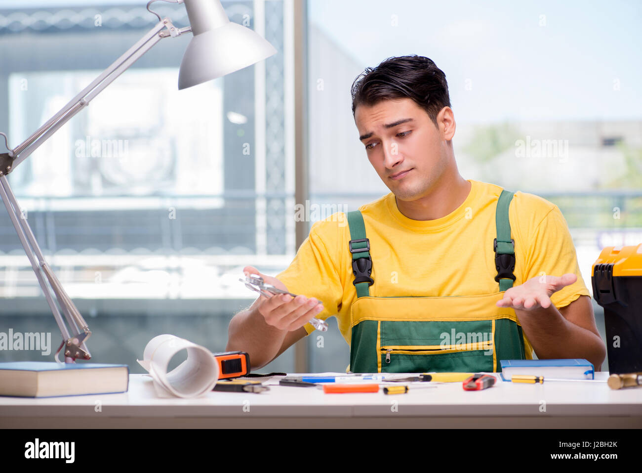 Construction worker sitting at the desk Stock Photo - Alamy