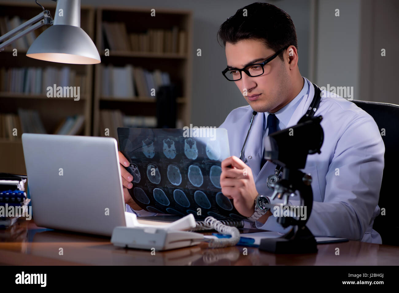 Young doctor working late in the office Stock Photo - Alamy