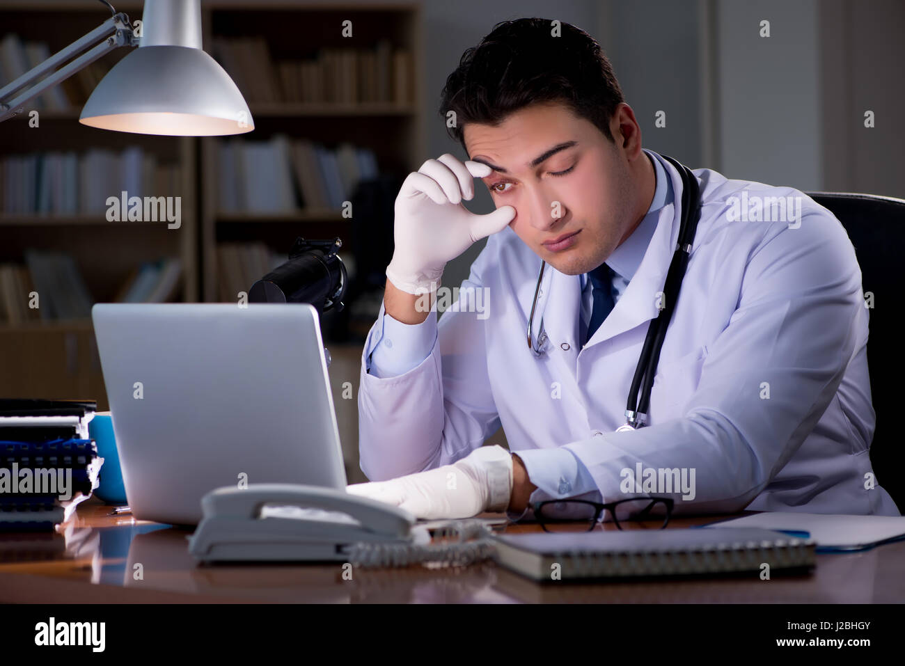 Young doctor working late in the office Stock Photo - Alamy