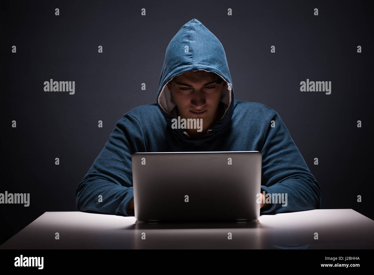 Computer hacker working in dark room Stock Photo - Alamy