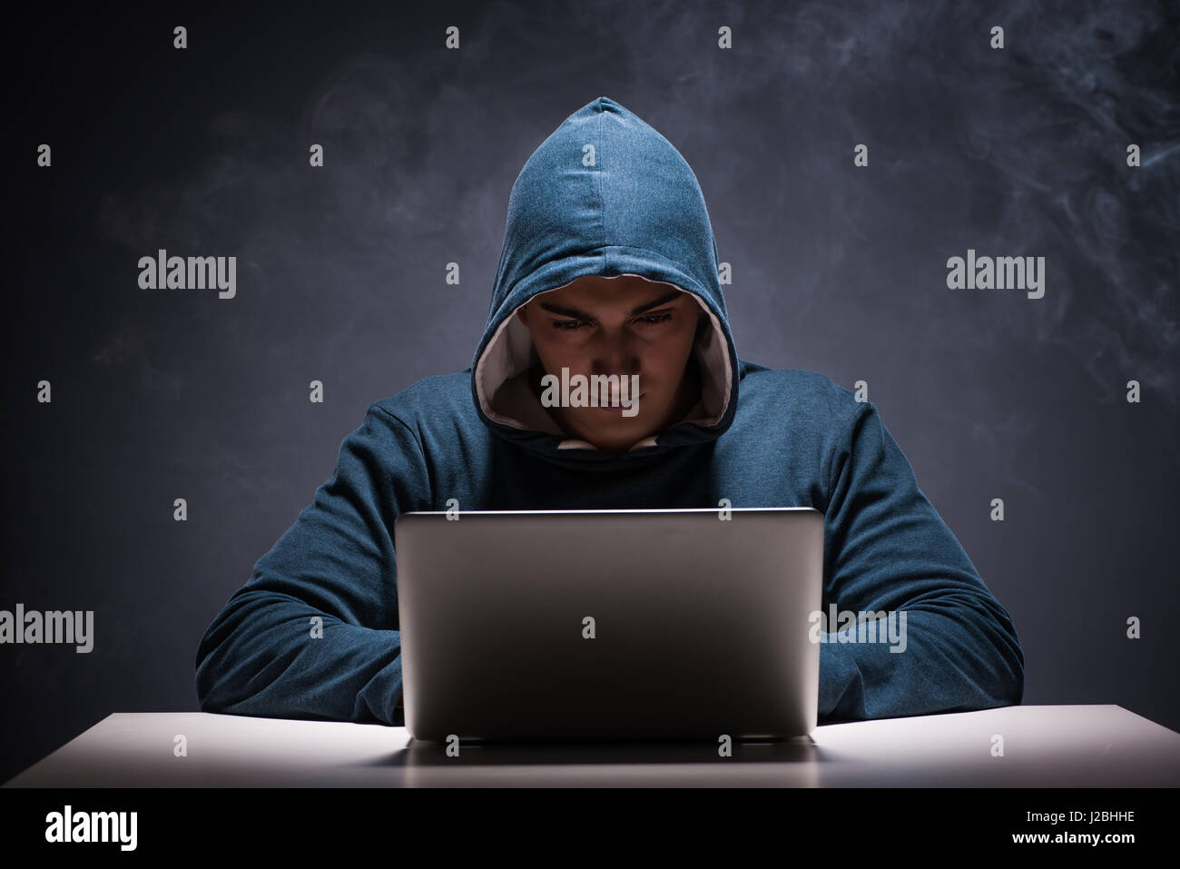 Computer hacker working in dark room Stock Photo - Alamy