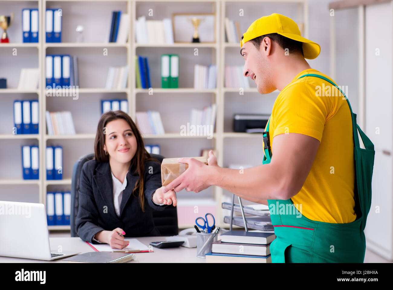 Postman delivering parcel to the office Stock Photo - Alamy