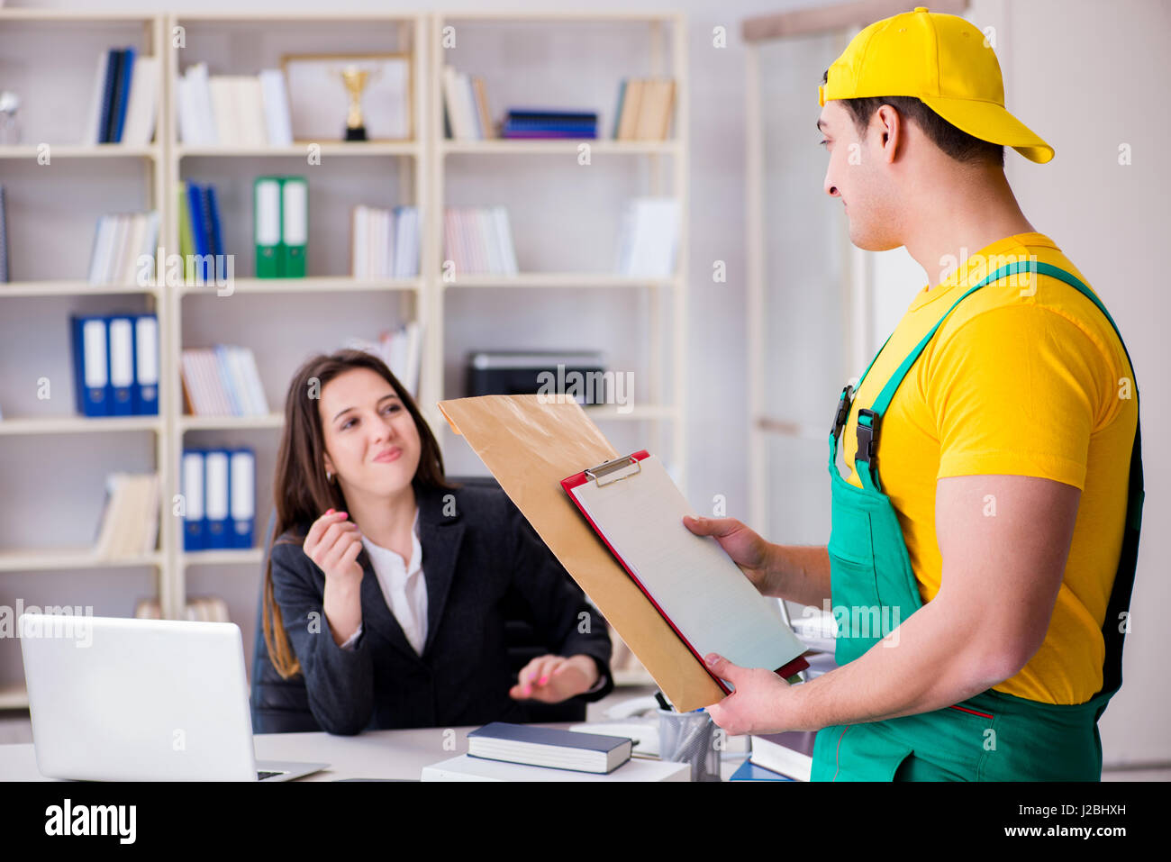 Postman delivering parcel to the office Stock Photo - Alamy