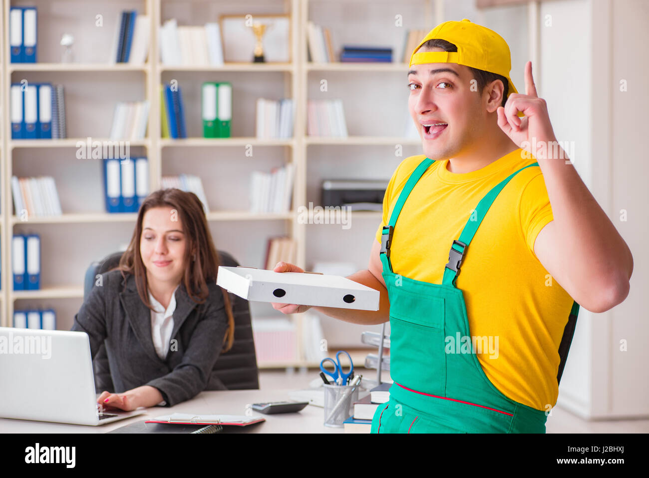 Postman delivering parcel to the office Stock Photo - Alamy