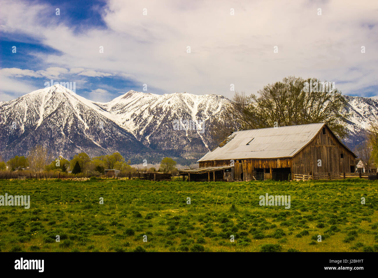 Old Rustic Barn In Valley Beneath Snow Covered Mountains Stock Photo ...