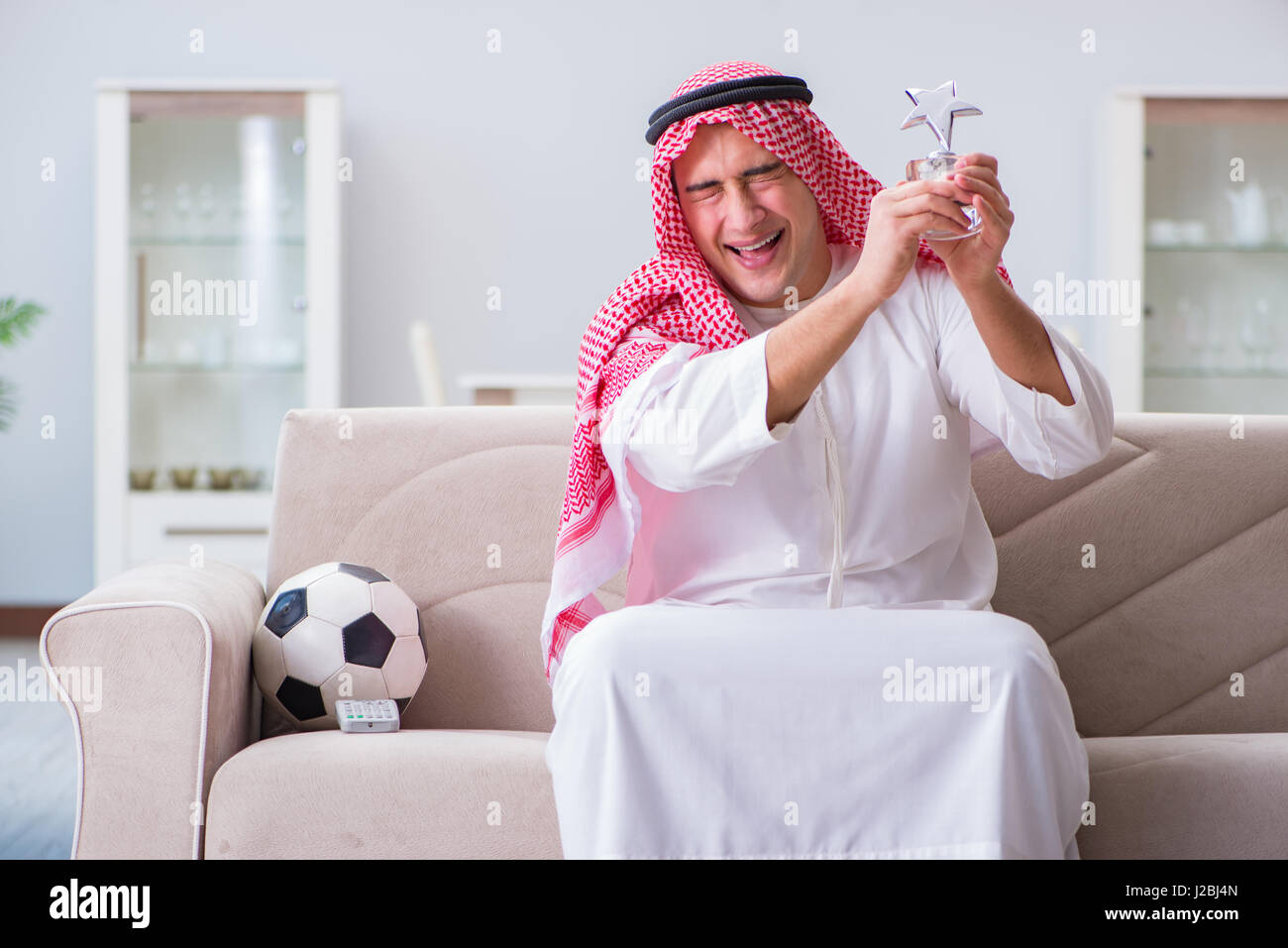 Excited arabian man watching football hi-res stock photography and ...