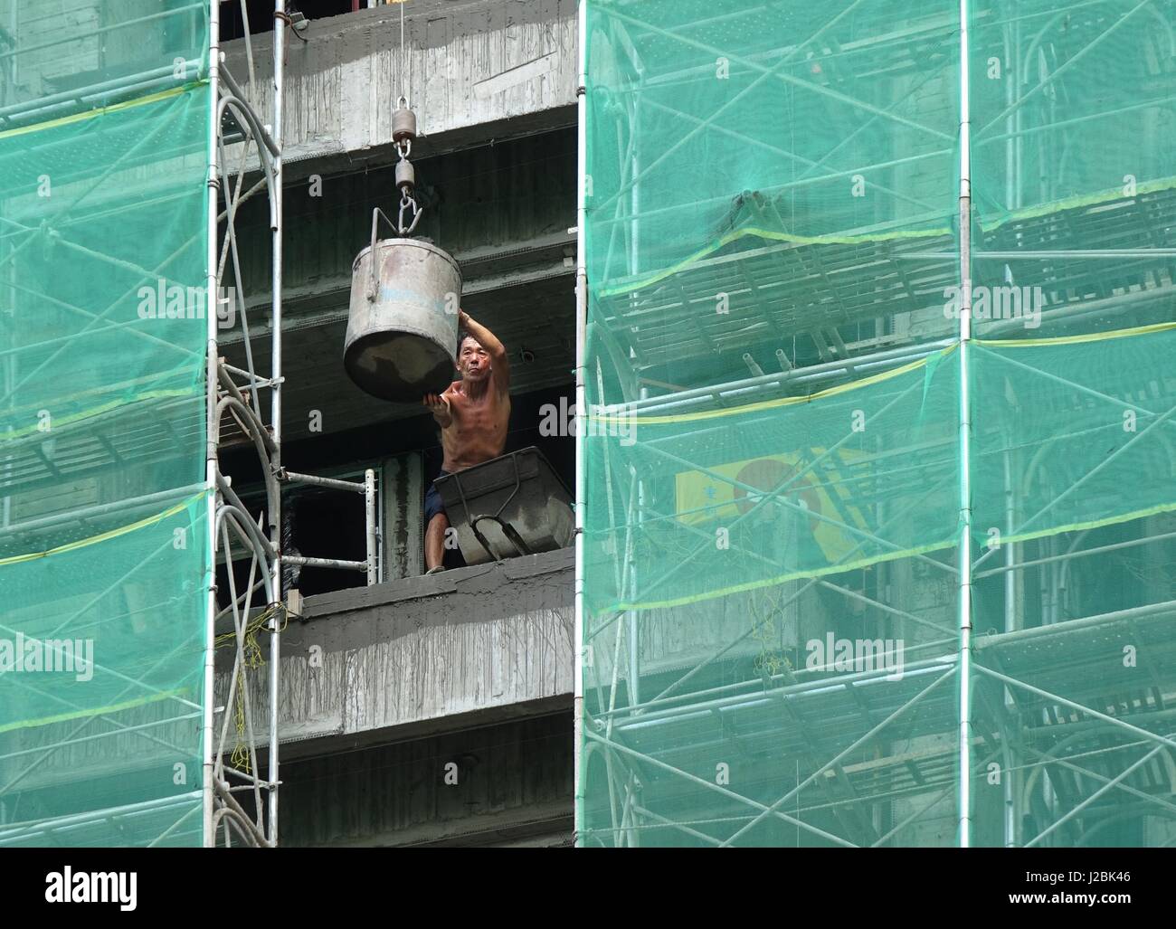 KAOHSIUNG, TAIWAN -- JULY 4, 2014: An elderly worker at a construction ...