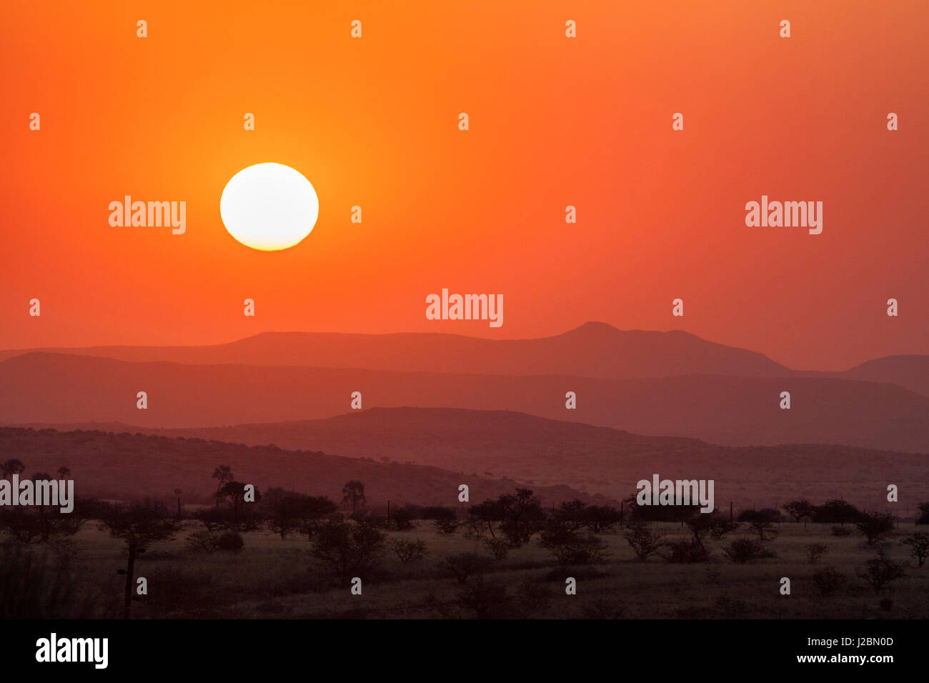 Africa, Namibia, Damaraland. Orange sunset over mountains. Credit as ...