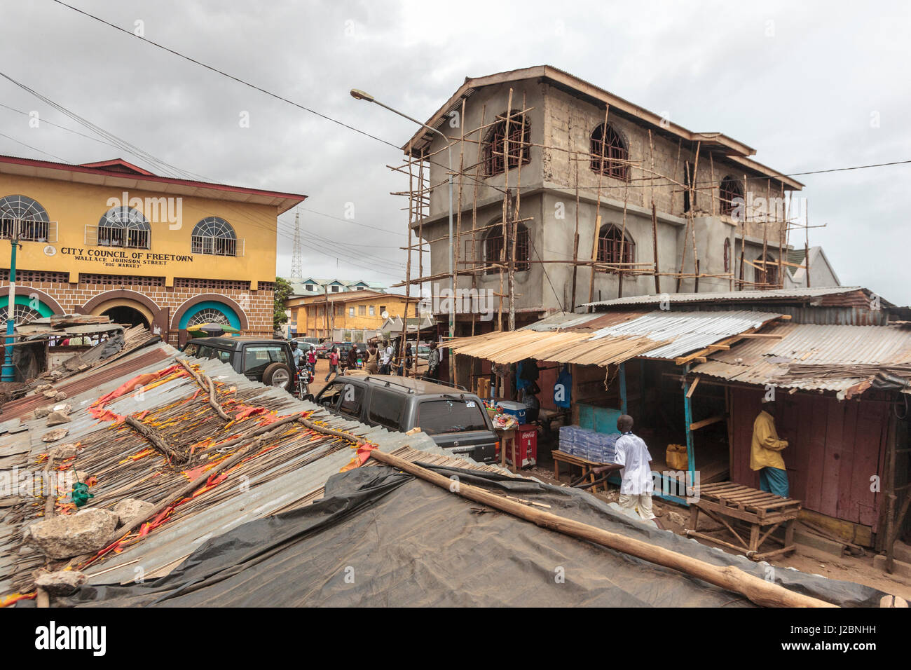 Africa, Sierra Leone, Freetown. Construction near an outdoor market ...