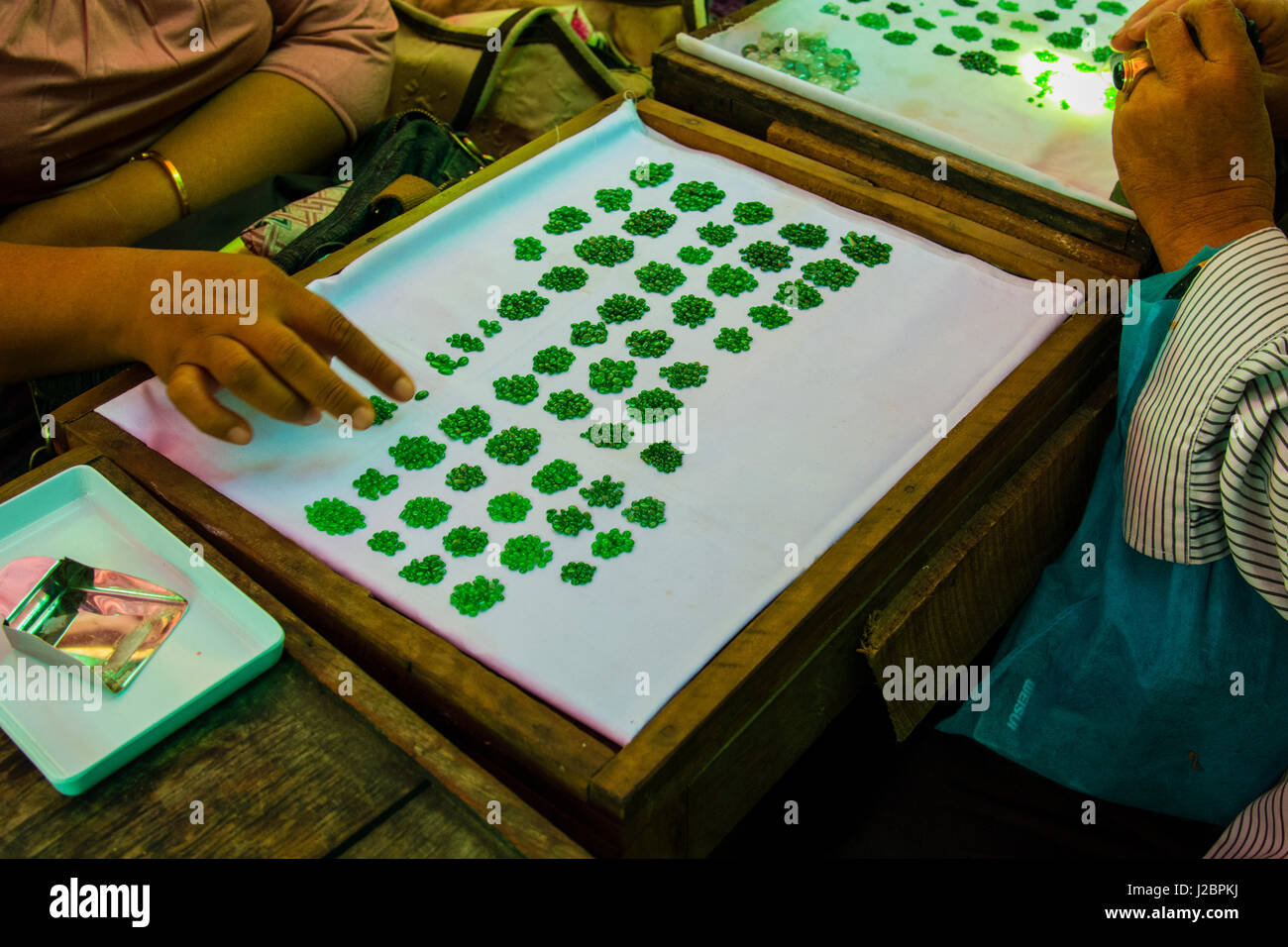 Myanmar. Mandalay. Jade market. Buyers and sellers examine tiny jade ...