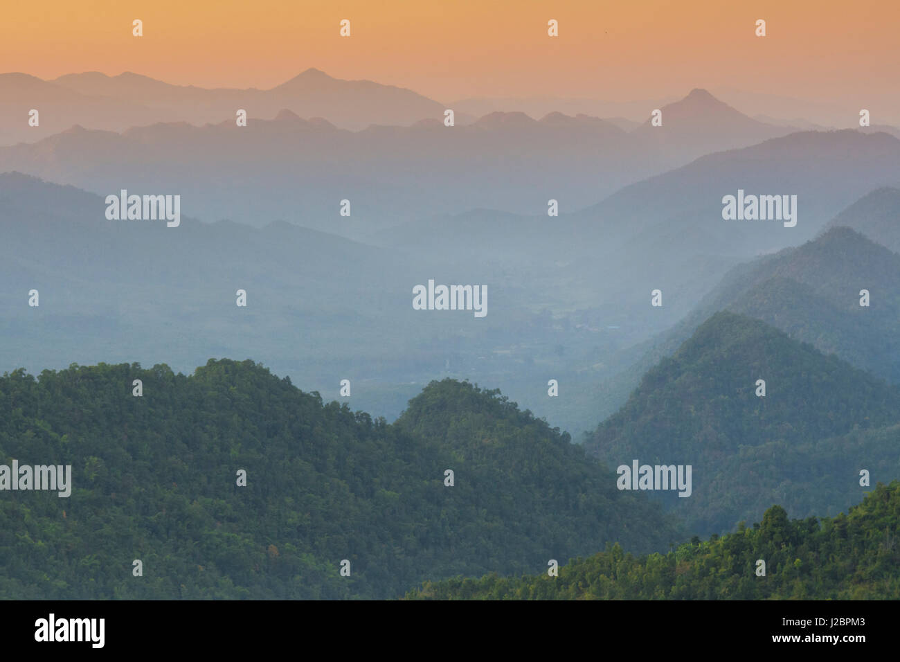 Myanmar. Shan State. Near Kalaw. Sunset over the ridges of haze-filled ...