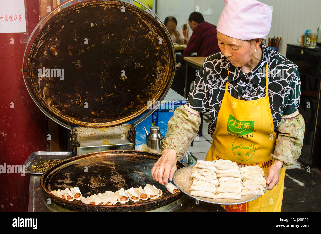 Muslim Hui woman preparing food Muslim market Xian, China Stock Photo ...