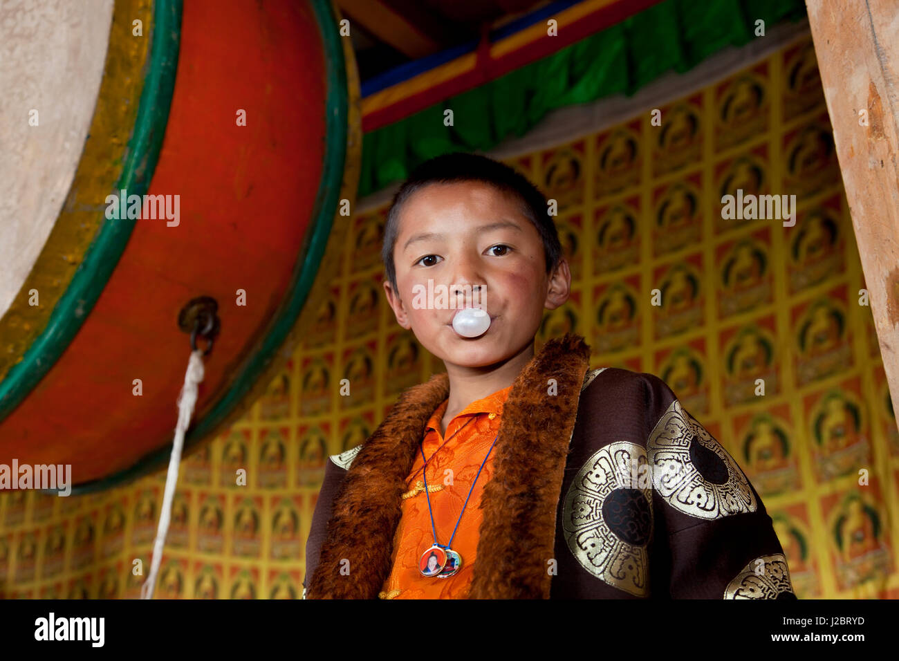 Young Buddhist monk blowing bubble gum at monastery, near Xinglong ...