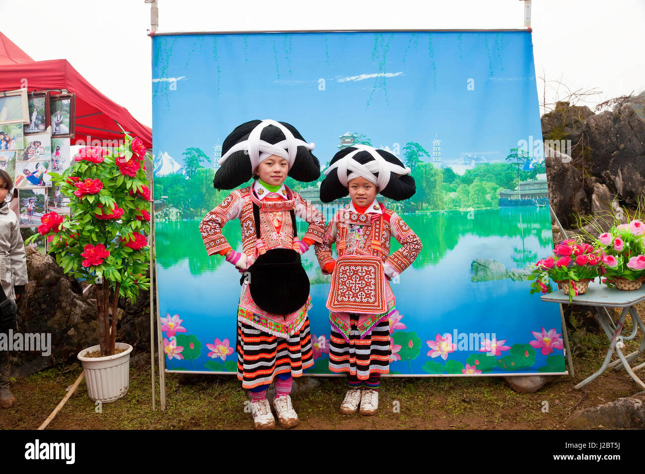 Long Horn Miao girls against photographers backdrop, Sugao, Guizhou ...