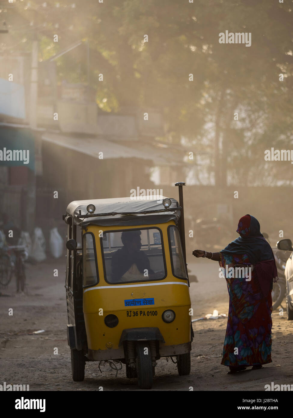 Woman paying fare to rickshaw driver in Chhatrasagar, Rajasthan, India ...