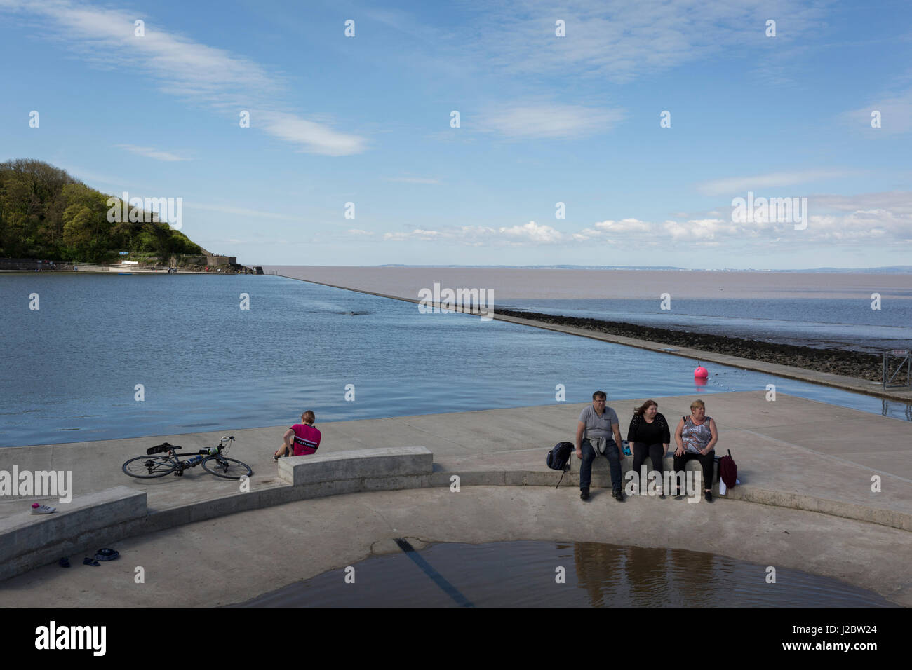 A family of three sit on the edge of a saltwater pool at Clevedon, on ...