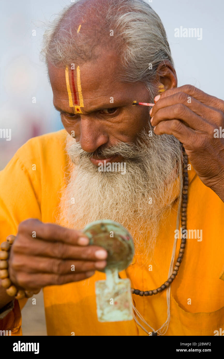 Sadhu making religious markings to face at Kumbh Mela festival, India ...