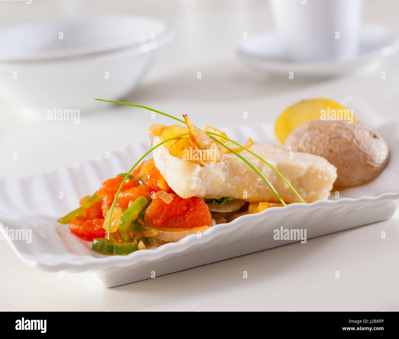 Grouper fillet served with fried garlic an vegetables Stock Photo - Alamy