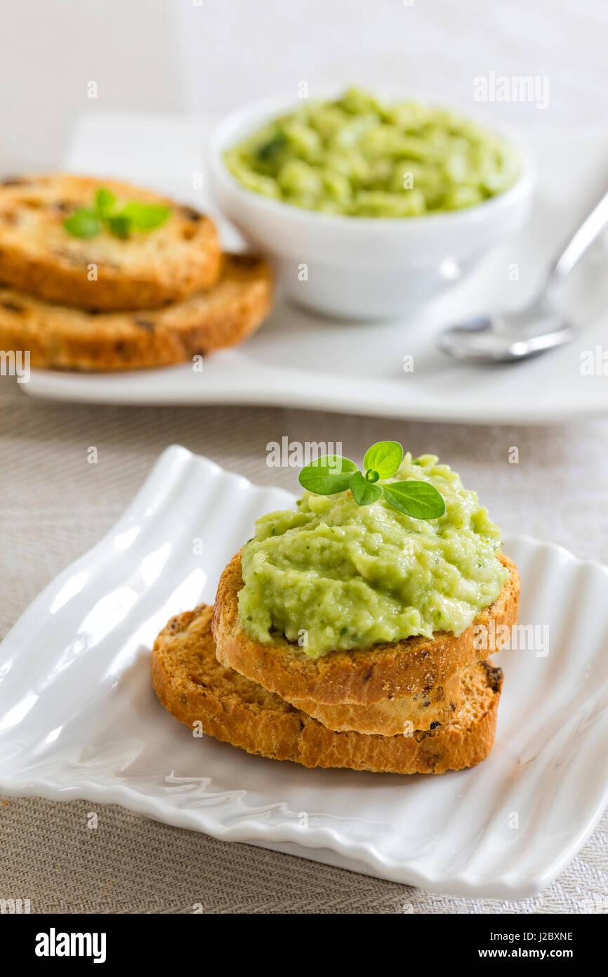Guacamole on toast served on a white table Stock Photo - Alamy